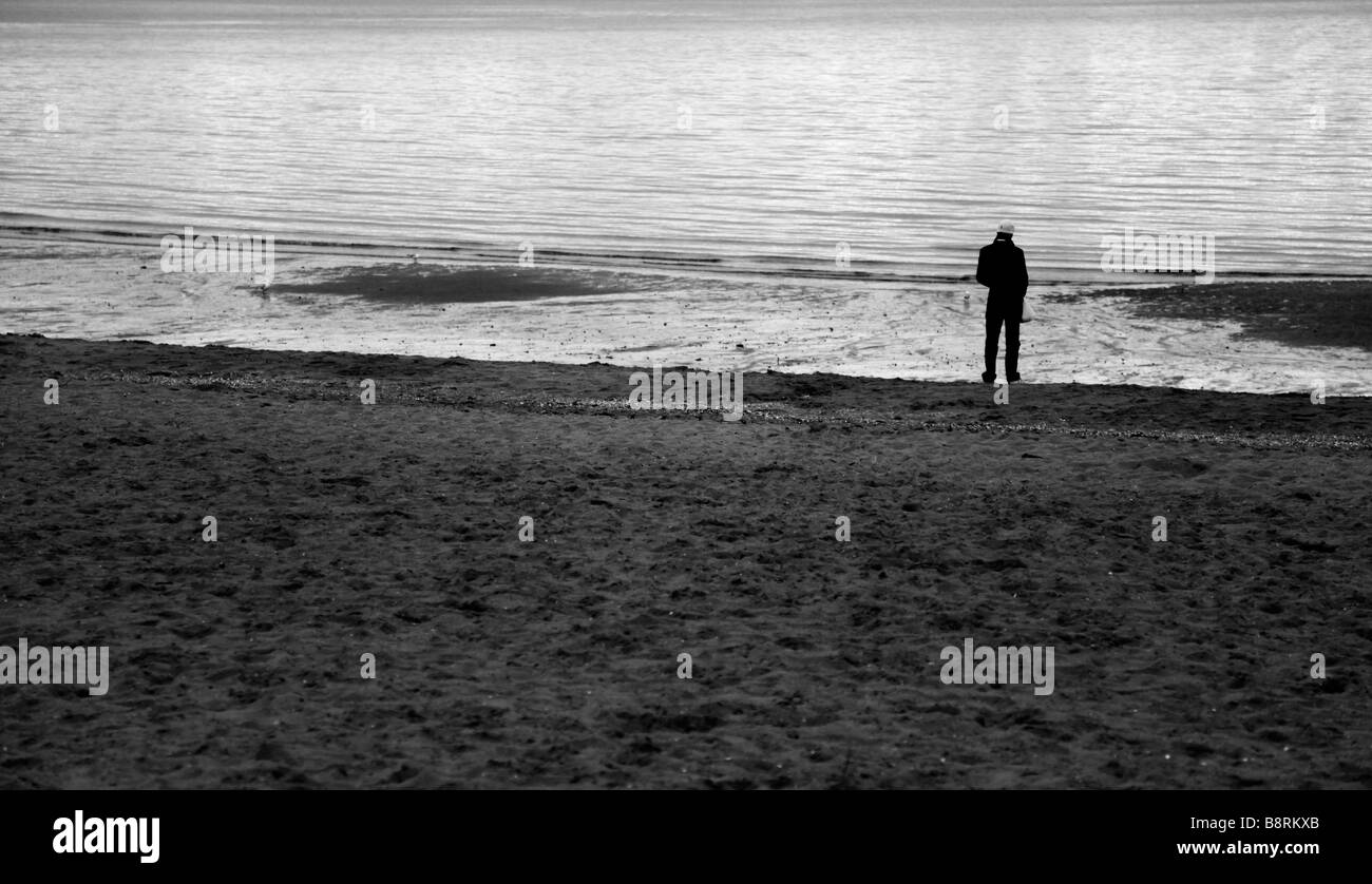 man overlooking ocean on a sandy beach Stock Photo - Alamy