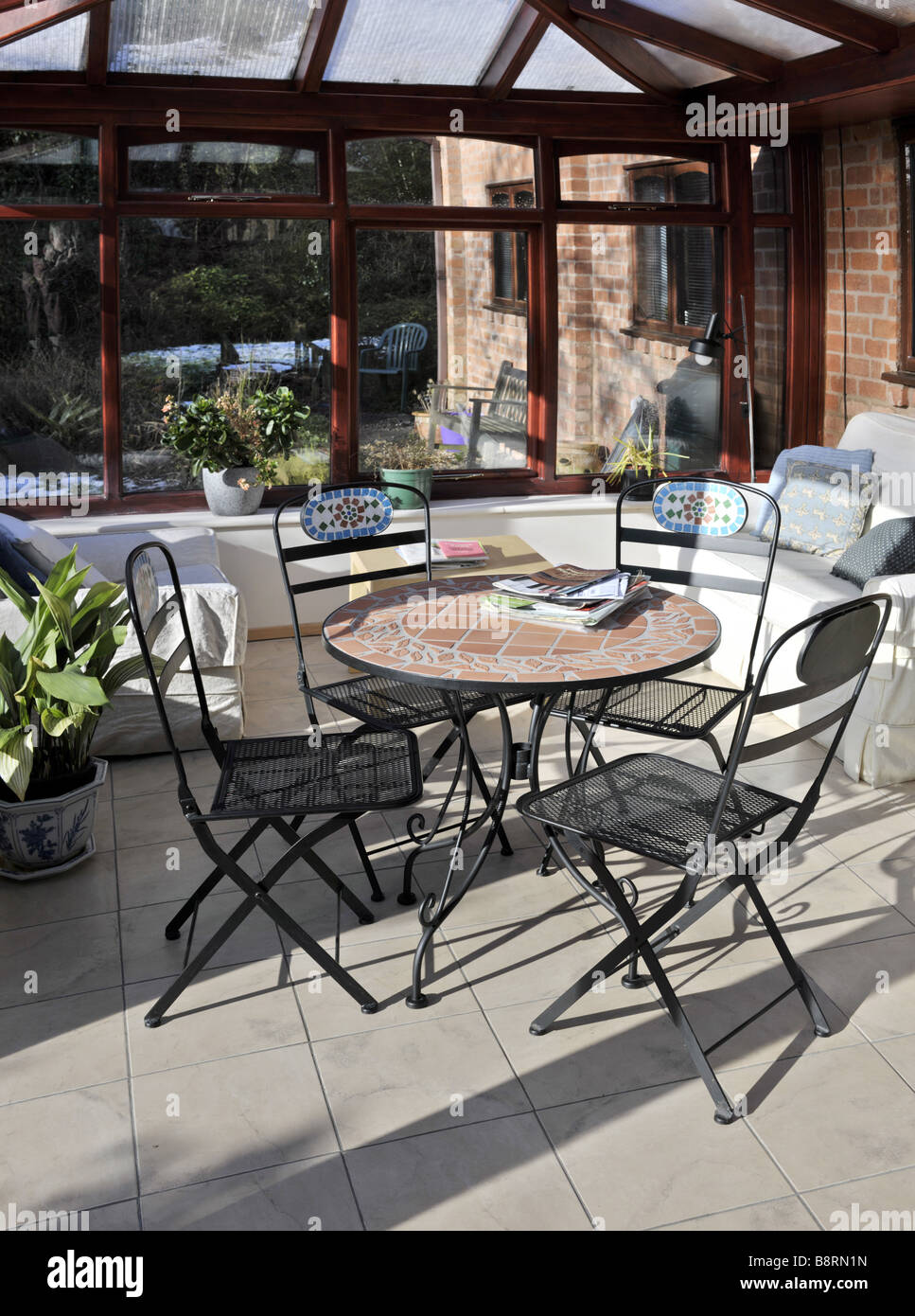 conservatory tables chairs plants room in house next to garden Stock ...
