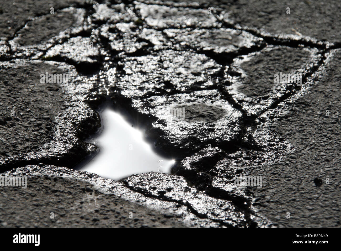 detail of hole and cracks in damaged road surface outdoors Stock Photo ...
