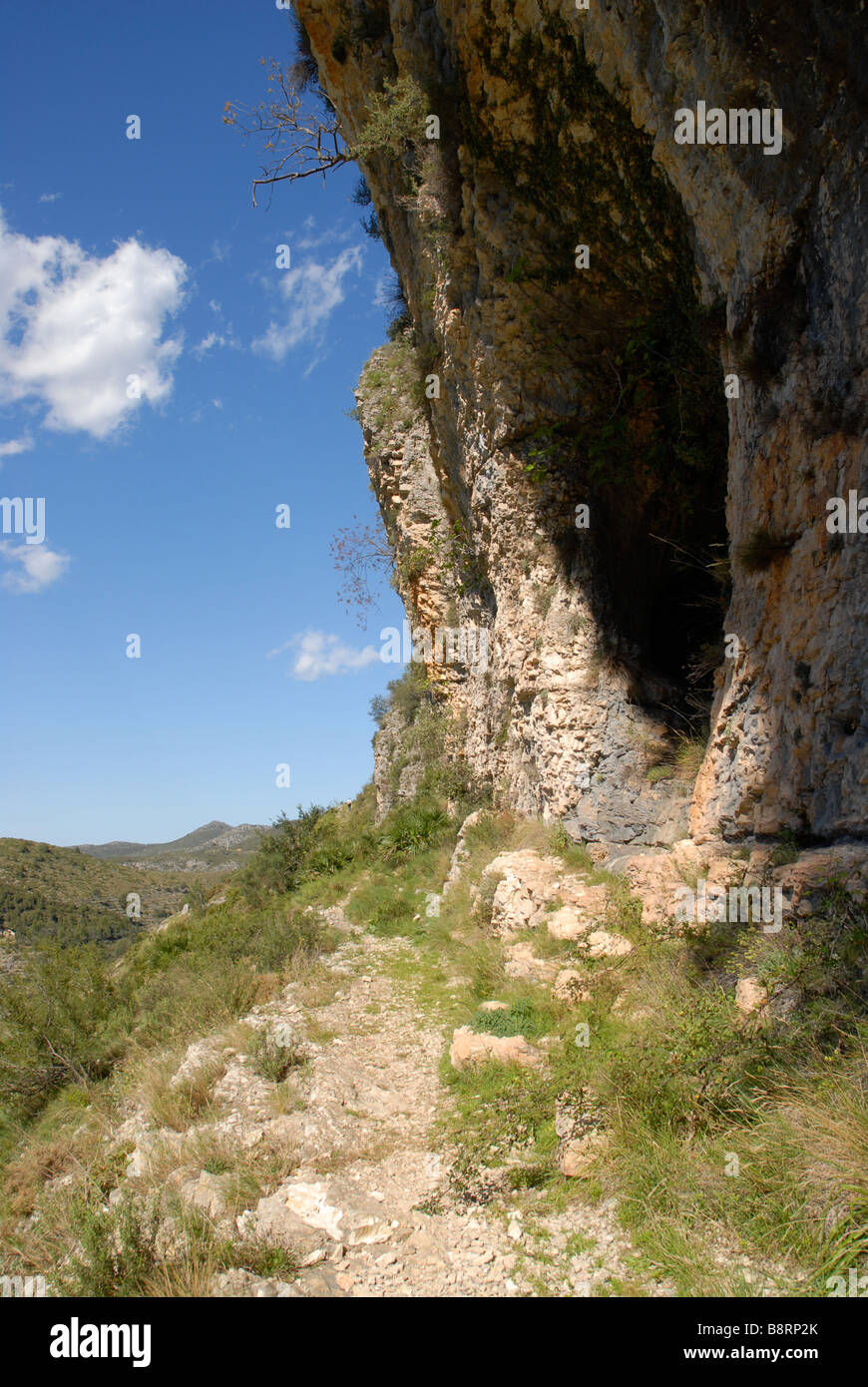 cave entrance in limestone cliff, Vall de Laguart, Benimaurell ...