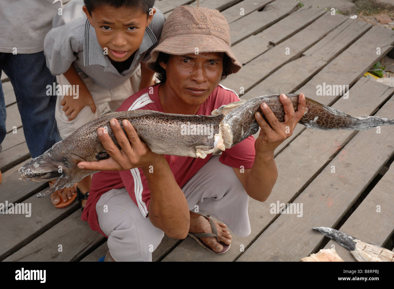 Fisherman holding up dried moray eel Semporna Sabah Malaysia Borneo ...