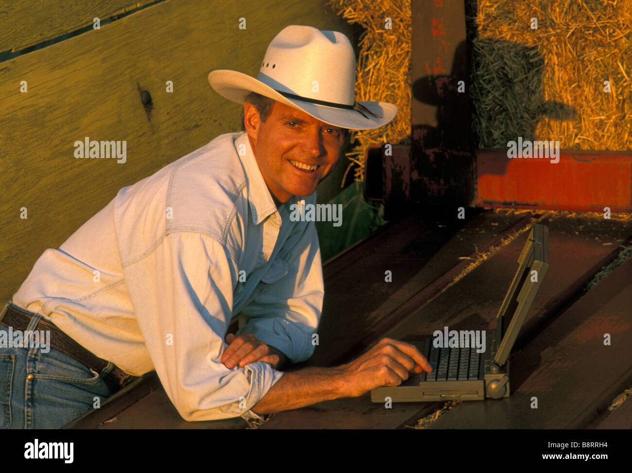 Cowboy working on laptop computer, USA, 1990s Stock Photo - Alamy