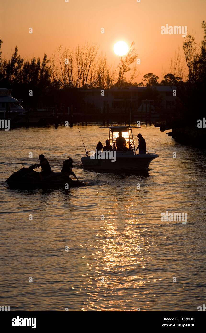 Bahamas Grand Bahama Island Freeport Setting sun silhouettes boaters ...