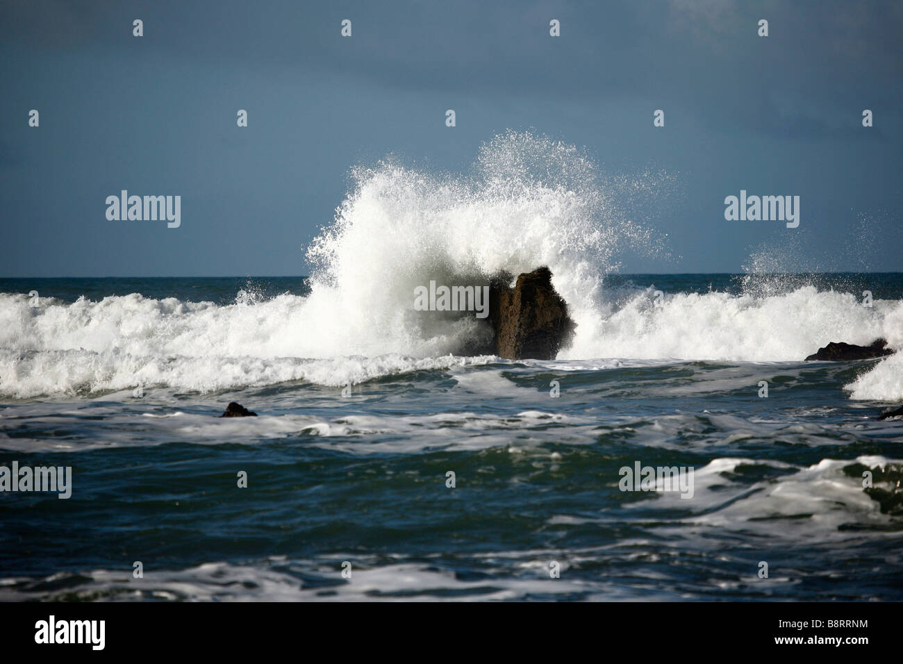 Wave breaking over a rock pinnacle at Widemouth bay,Cornwall.England,UK ...