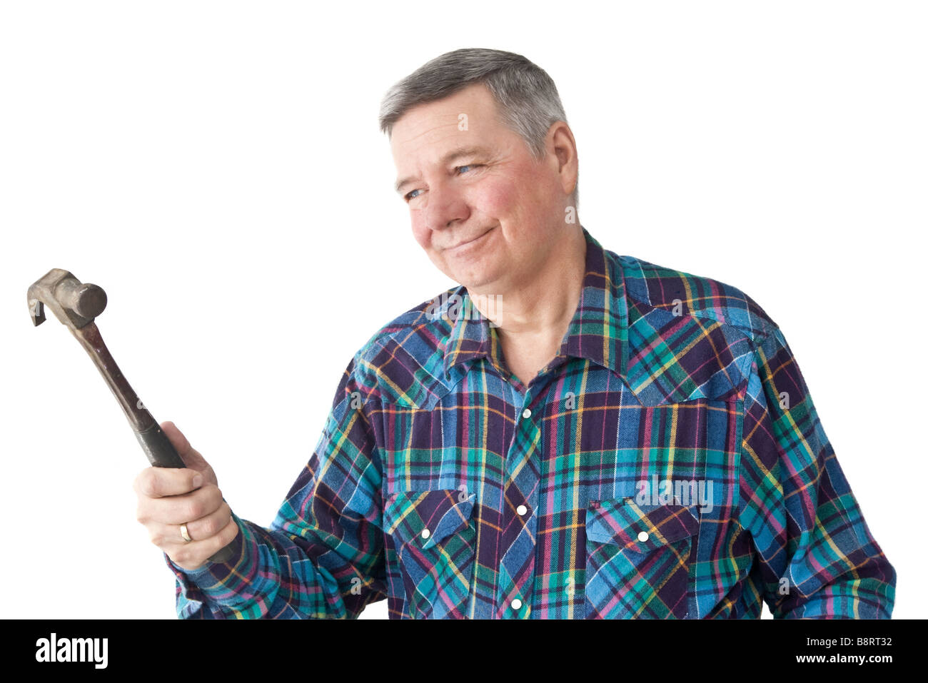 Mature handyman admiring the hammer he is holding isolated on a white ...
