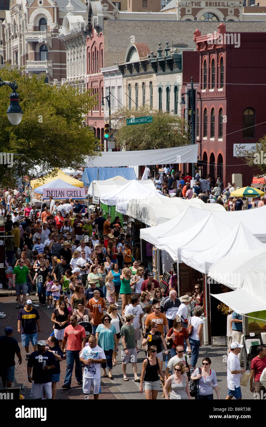 People walk down 6th street during the Pecan Street Festival in Austin ...