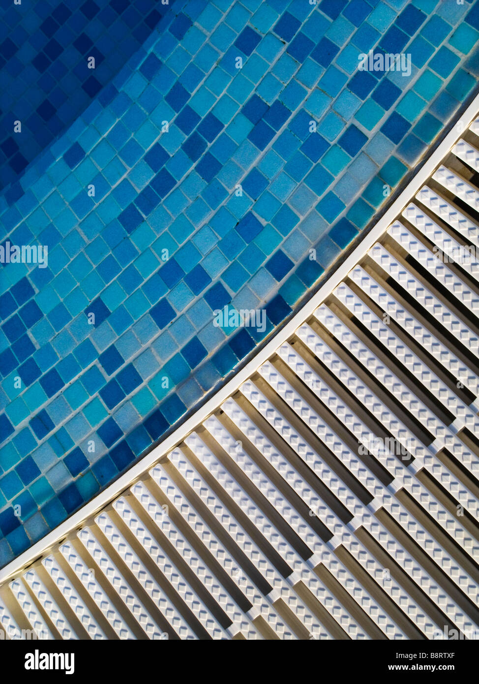 White plastic grill at side of blue mosaic lined swimming pool Stock ...