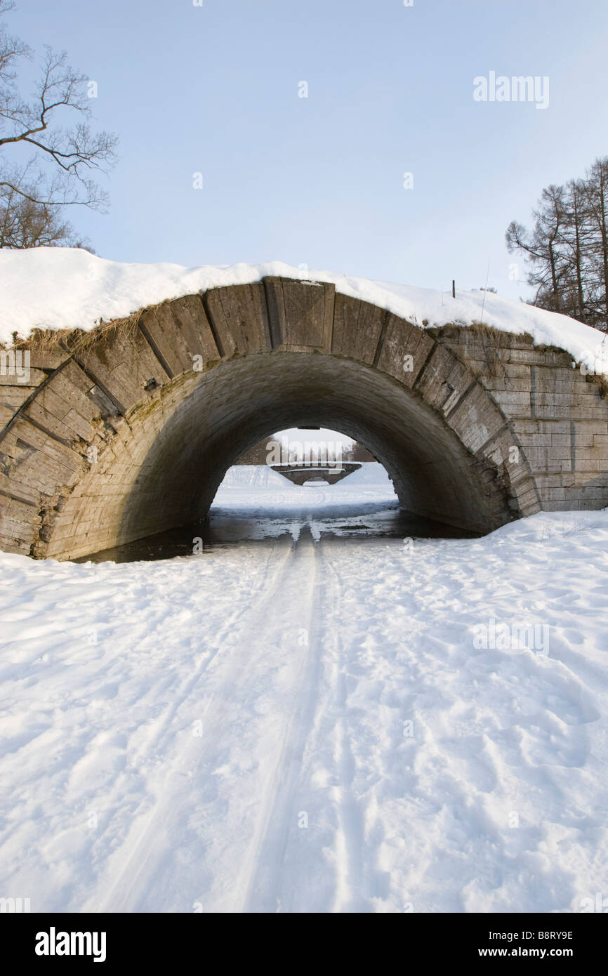 Ski track on frozen river passing under the arched bridge Stock Photo ...