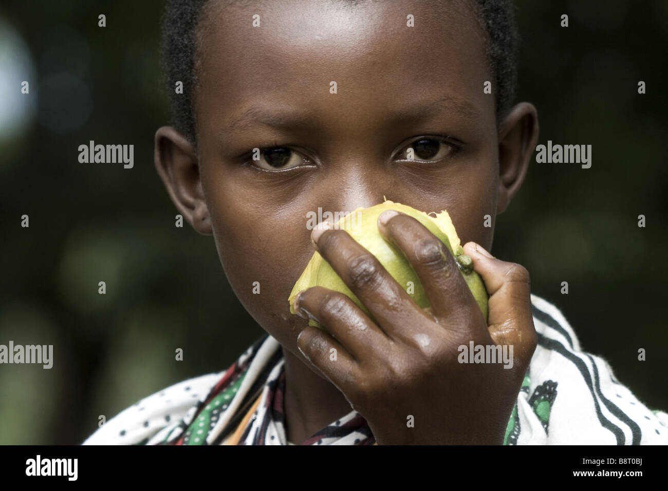 Digo girl eating a mango, Kenya Stock Photo - Alamy