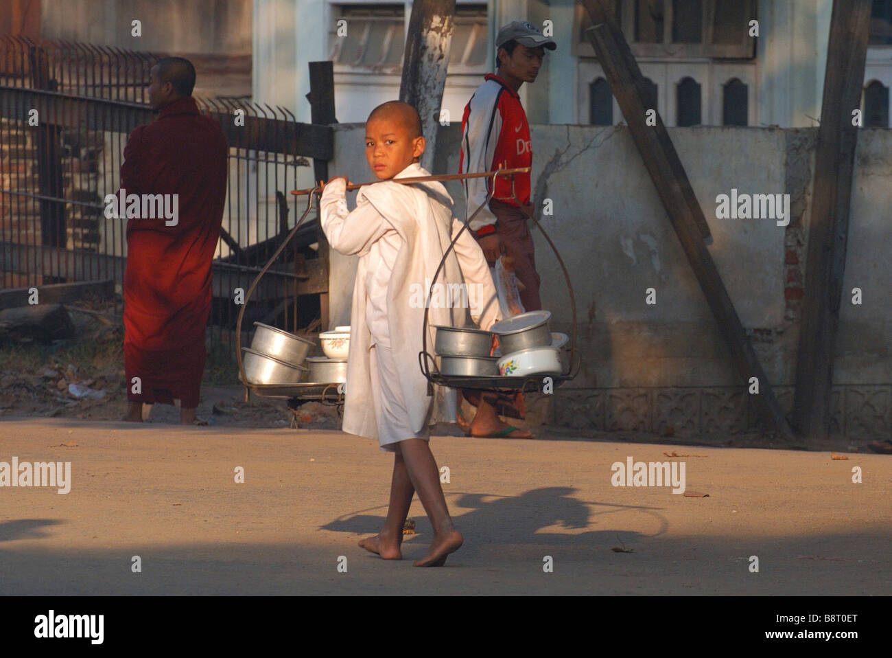 young boy carrying pots through the street, Burma Stock Photo - Alamy