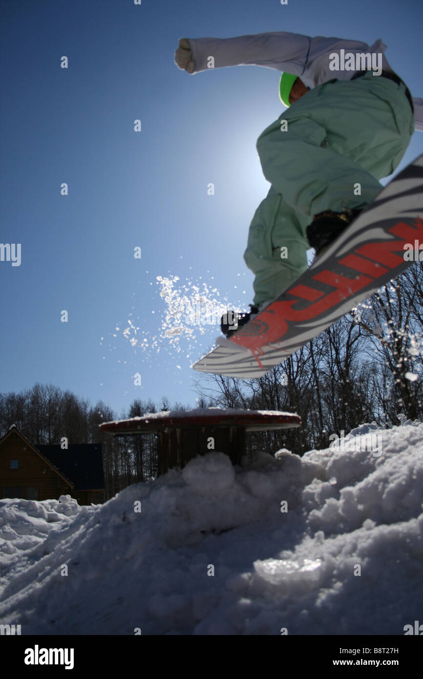 Snowboard olly 180 over cable reel Stock Photo - Alamy