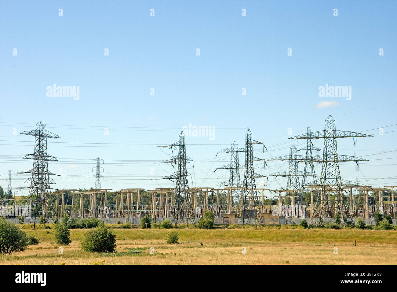 Electricity pylons and substation by a field in the sun Stock Photo - Alamy