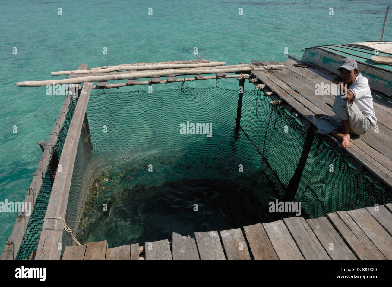 Suluk fish pen alongside house on stilts on reef flat Semporna Sulu Sea ...