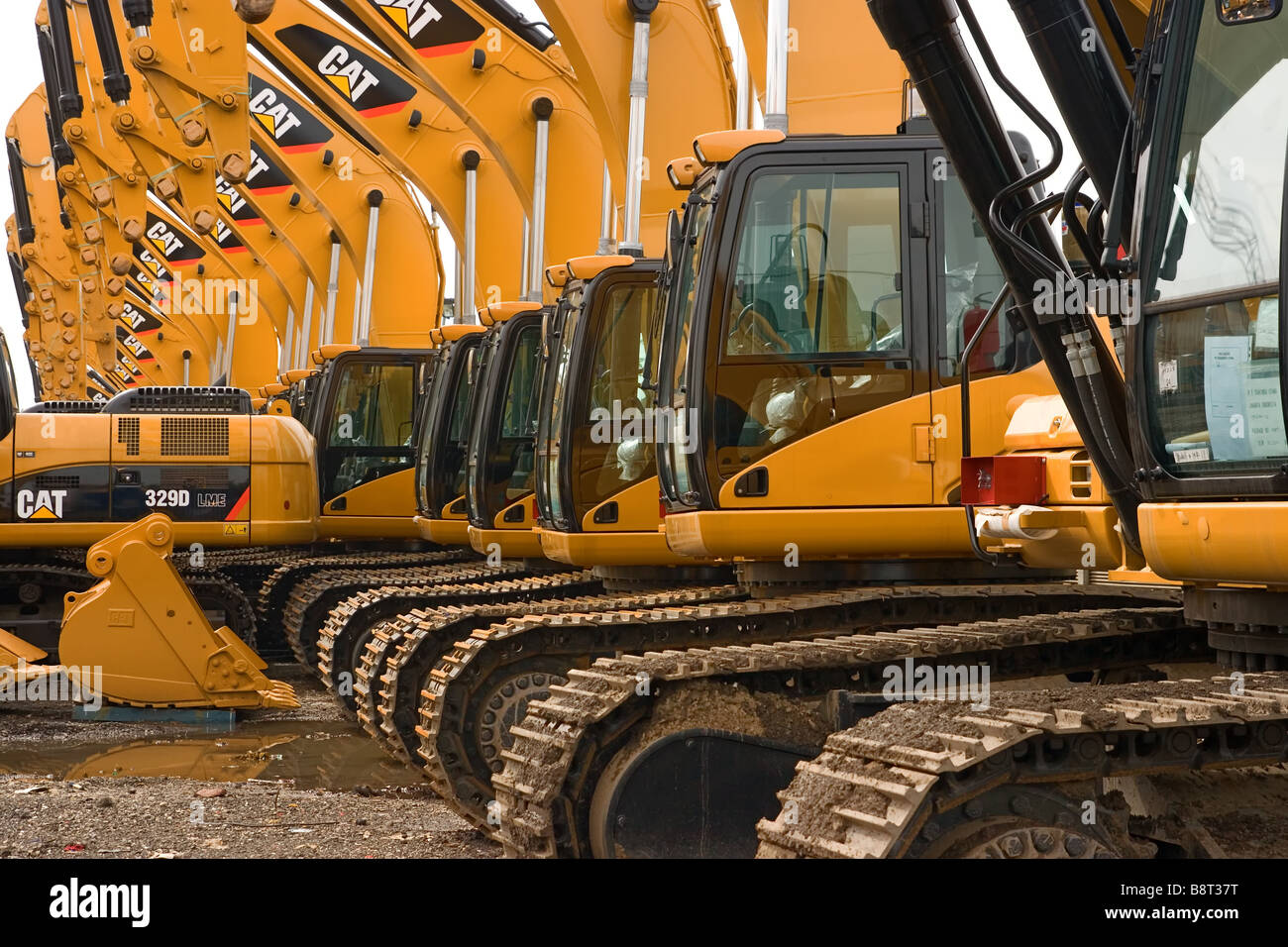 caterpillar excavator neatly parked in open yard storage in repetitive ...