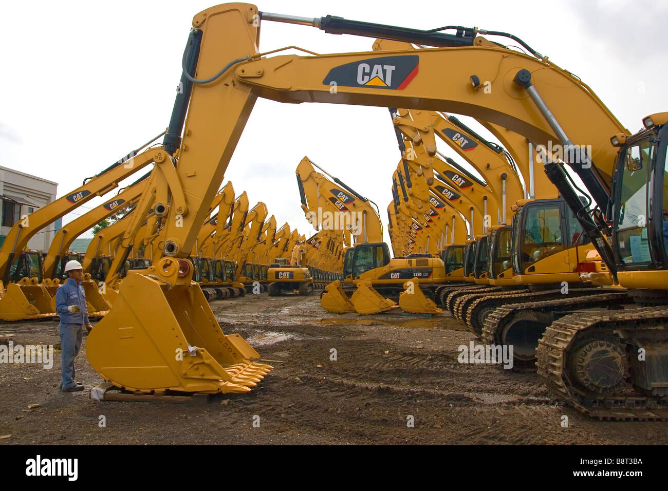 engineer working on caterpillar excavator which are neatly parked in ...