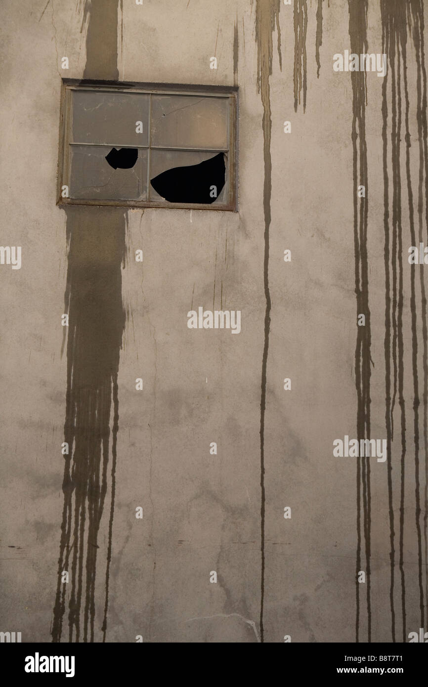 water flowing down side of weathered wall with broken window Stock ...