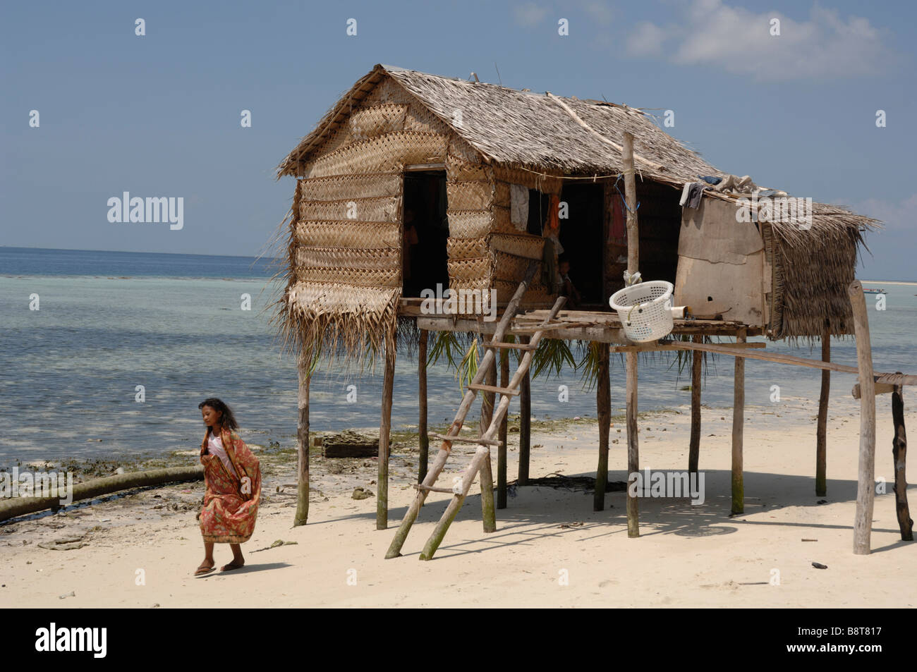 Bajau house on wooden stilts and woman walking Pulau Maiga Semporna ...