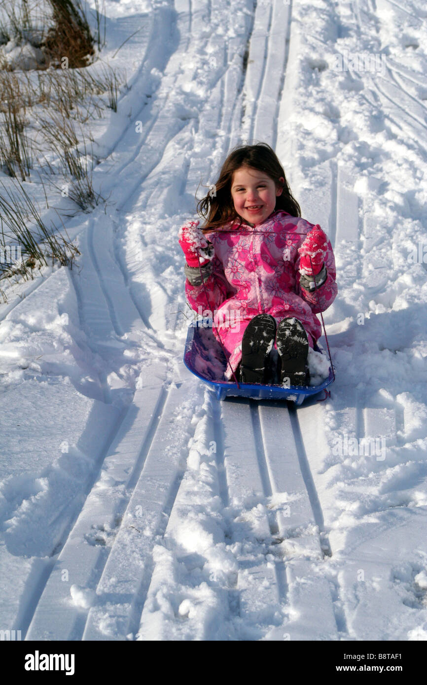 Girl sledging in the snow in the Garw Valley Mid Glamorgan South Wales ...