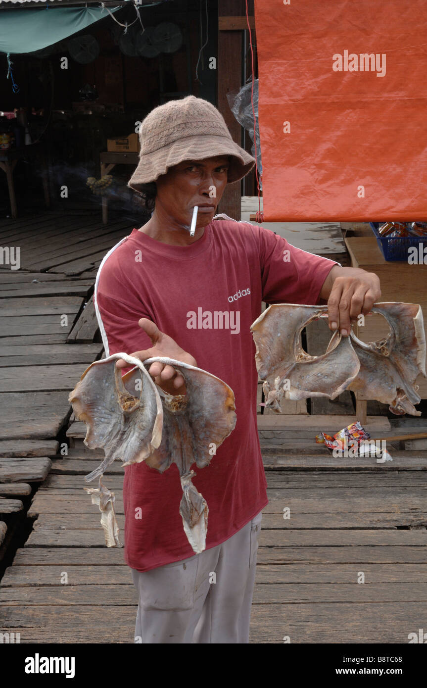 Fisherman holding up dried blue spotted rays Taeniura lymma dried fish ...