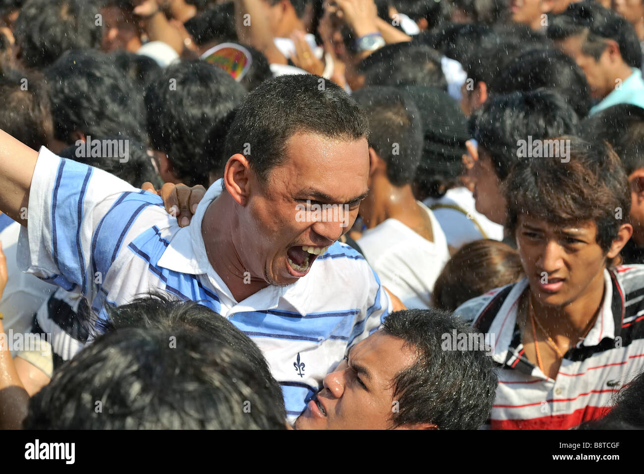 Devotees receiving holy water at tattoo festival at Wat Bang Phra ...