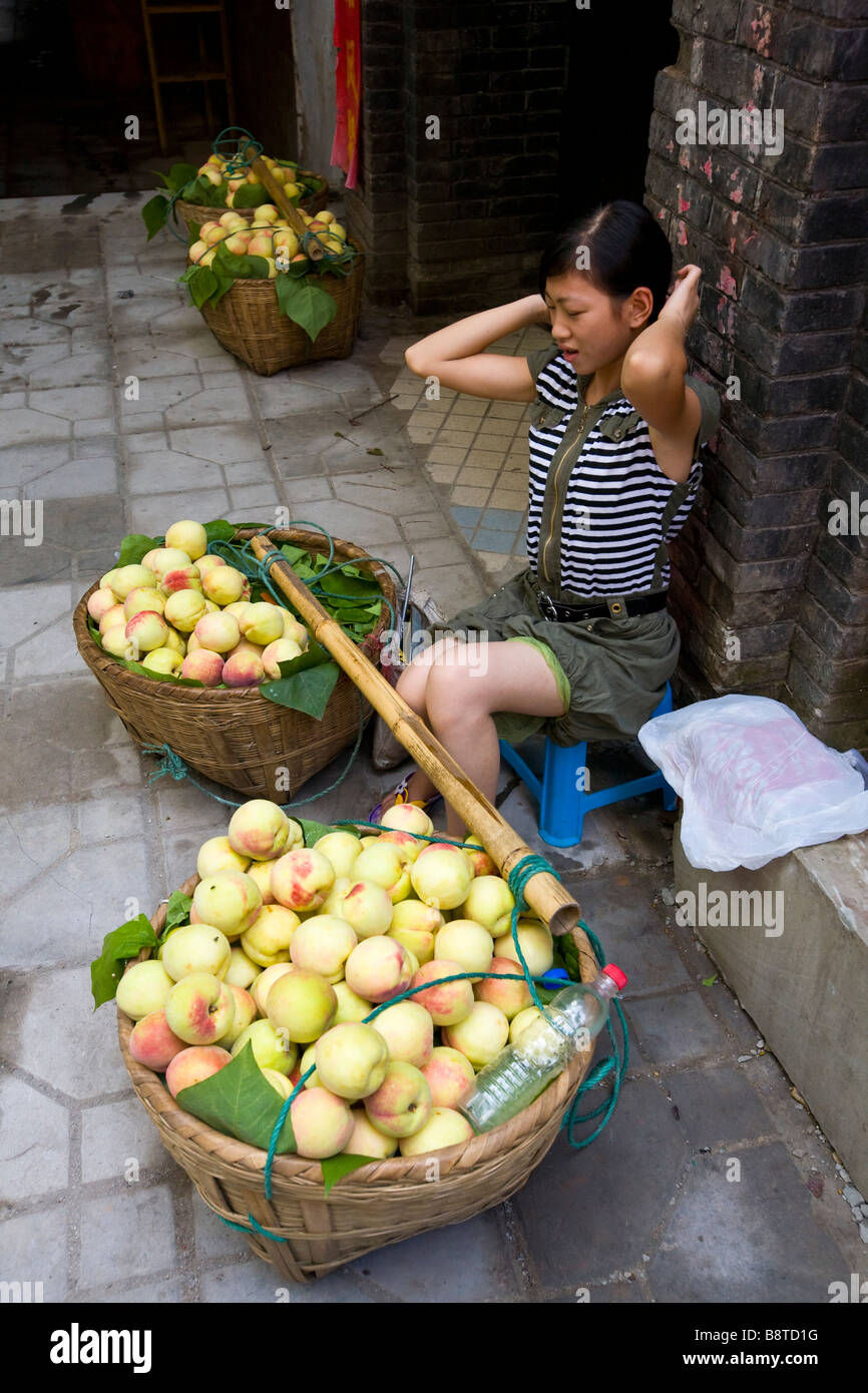 A chinese adolescent selling peaches in Chongqing city, China Stock ...