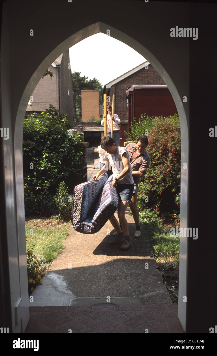 Family moving house carrying mattresses through the front door Stock ...