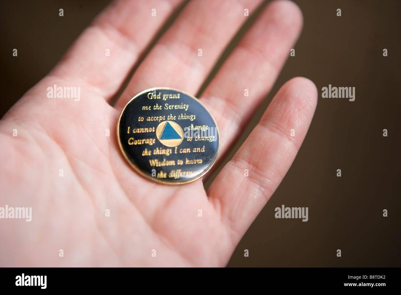 hand holding five year anniversay "chip" or coin, Alcoholics Anonymous ...