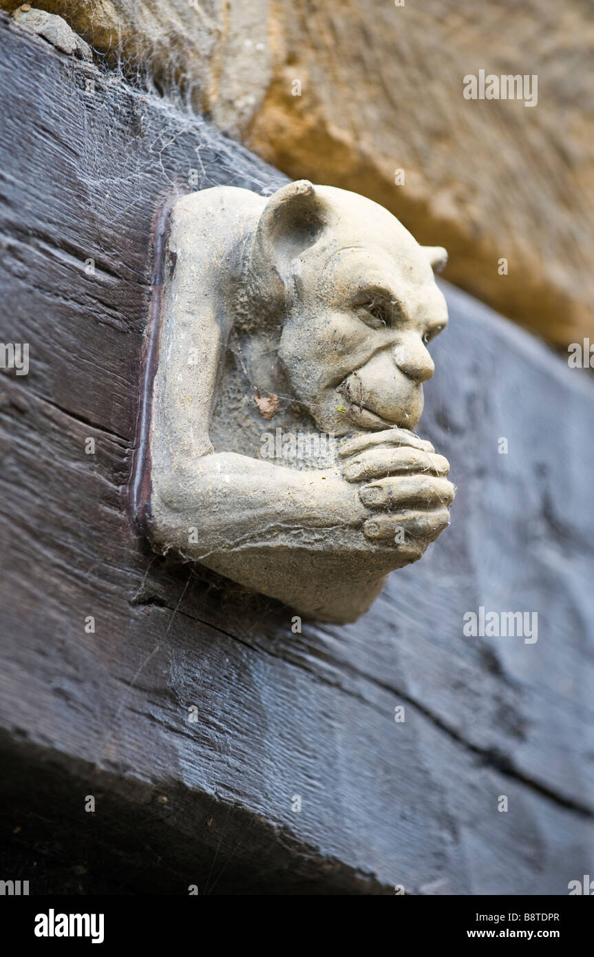 Gargoyle above a door clasping its hands looking down Stock Photo - Alamy