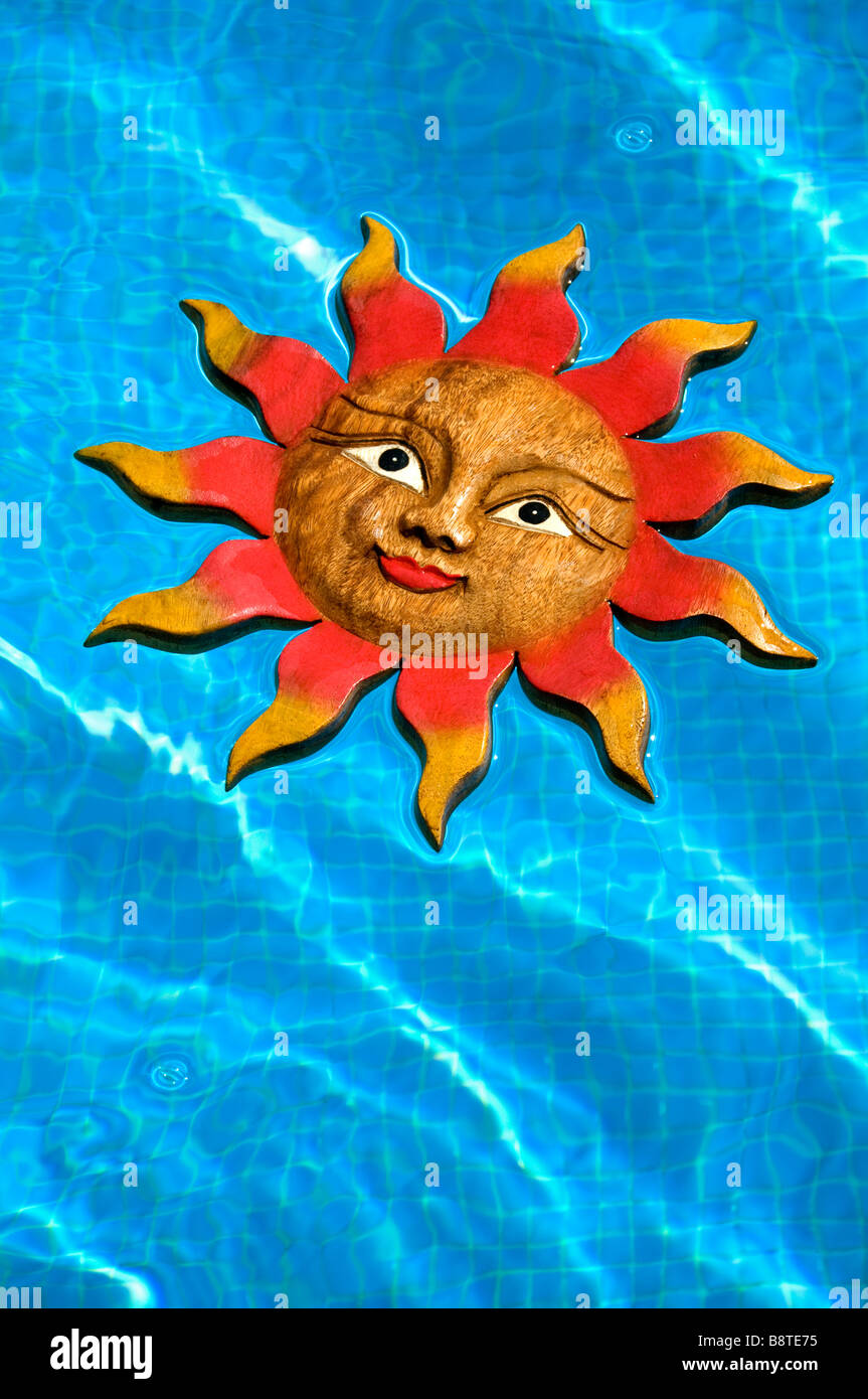 Smiling sun face icon floating in sunny blue vacation holiday swimming ...