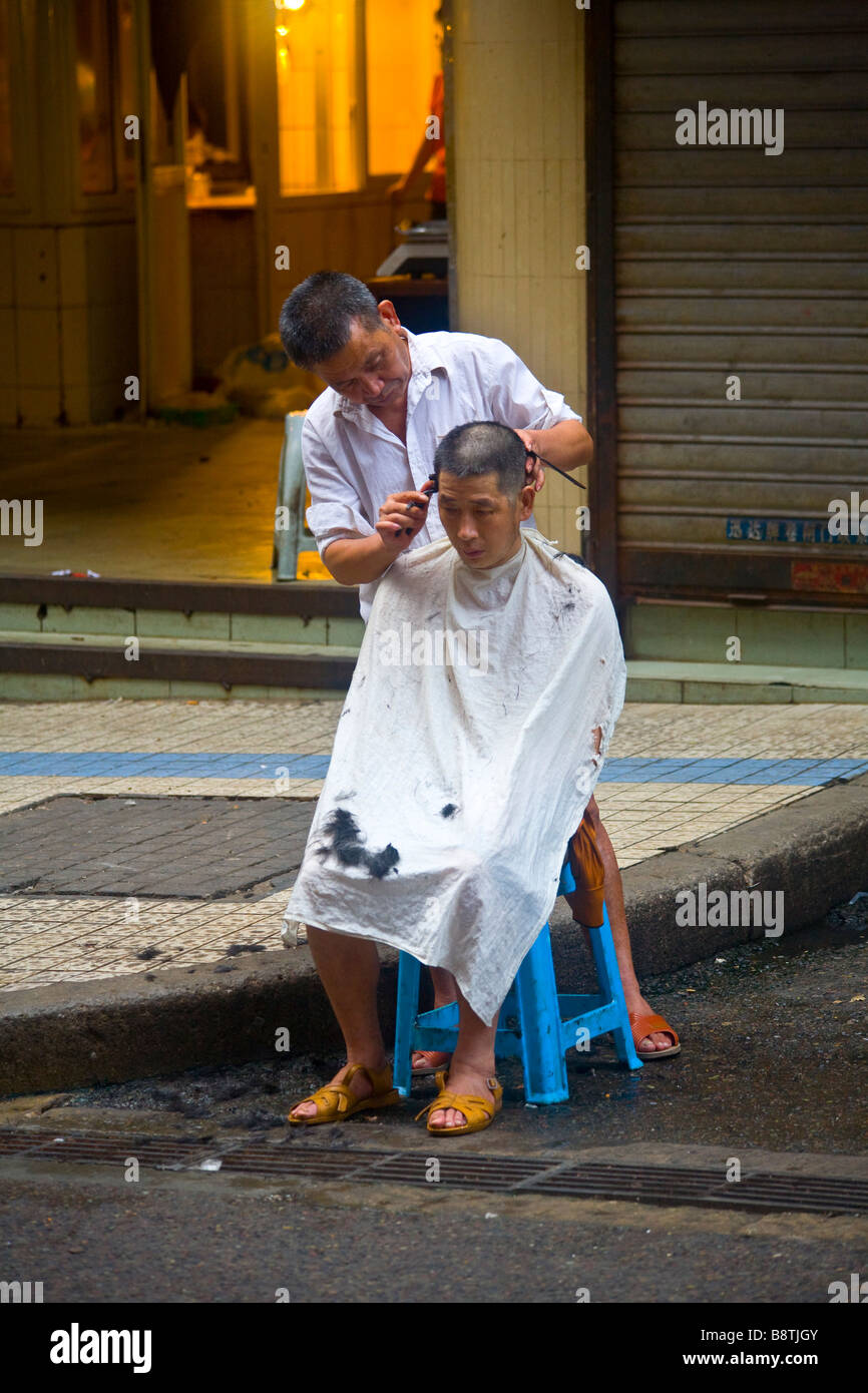 A haircut on the street in downtown Chongqing City, China Stock Photo ...