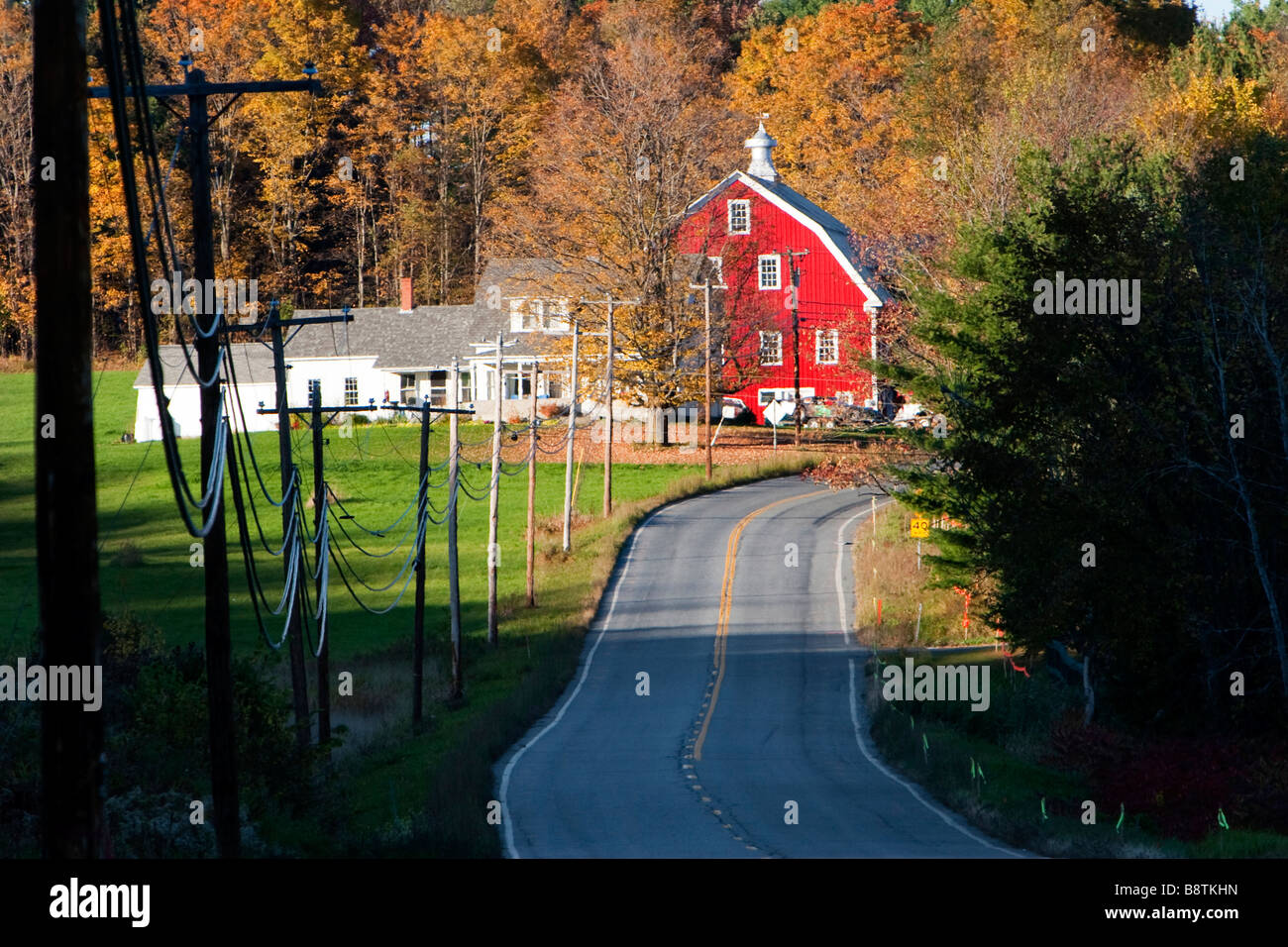 A road winds through trees near a barn in rural Vermont USA October 10 ...