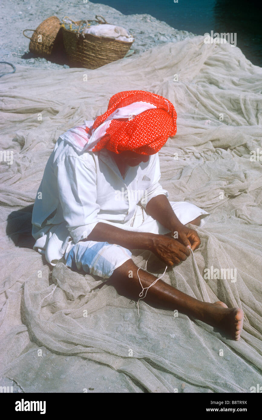 Arab fisherman mending nets in Sharjah Khor Fakkan UAE Arabian Sea ...