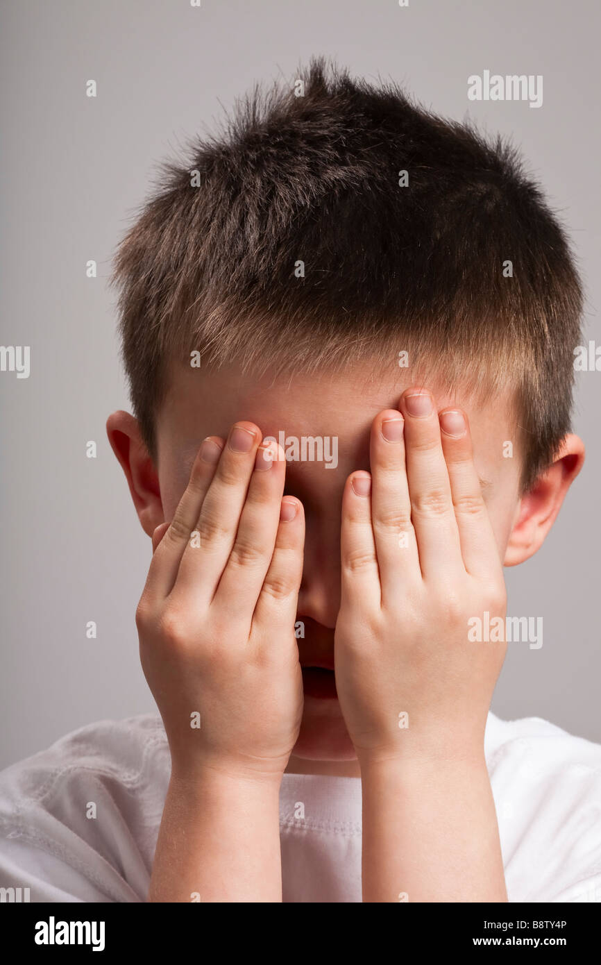 Little boy hiding his face with his hands Stock Photo - Alamy