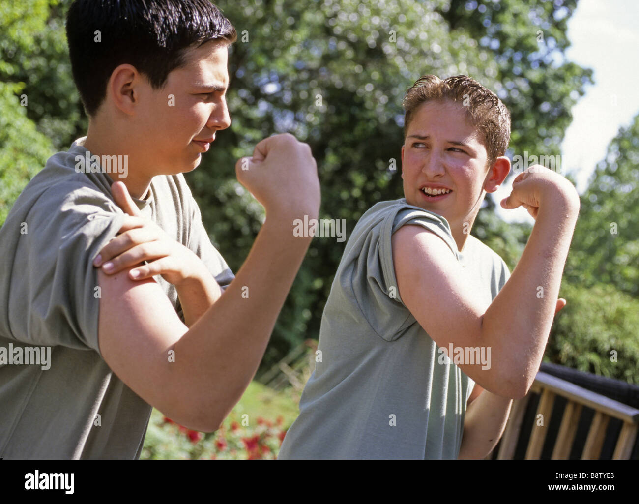 Boys shows biceps Stock Photo - Alamy