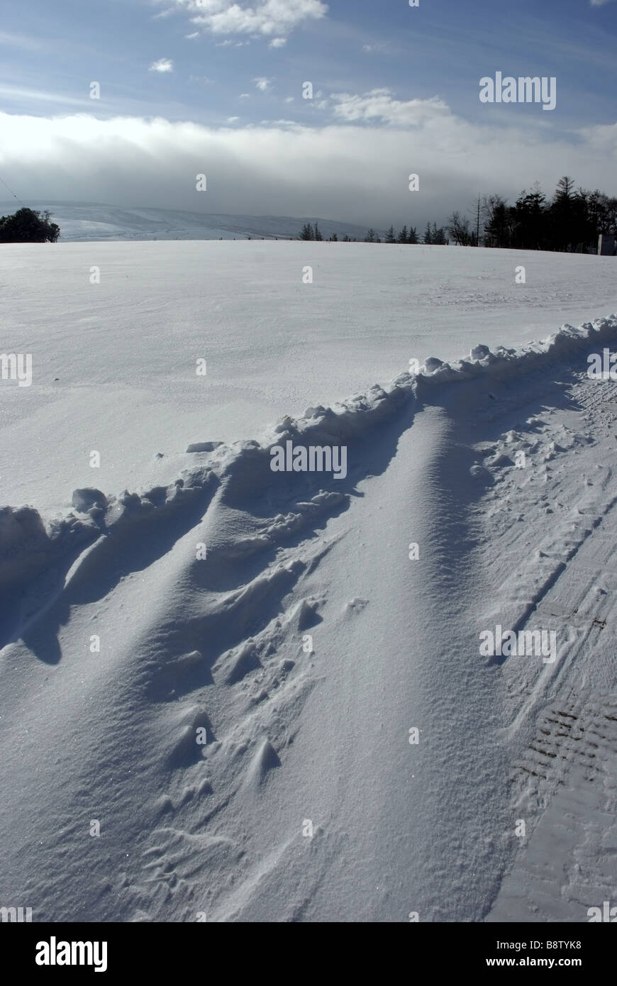 Snowdrifts across edge of a road Stock Photo - Alamy