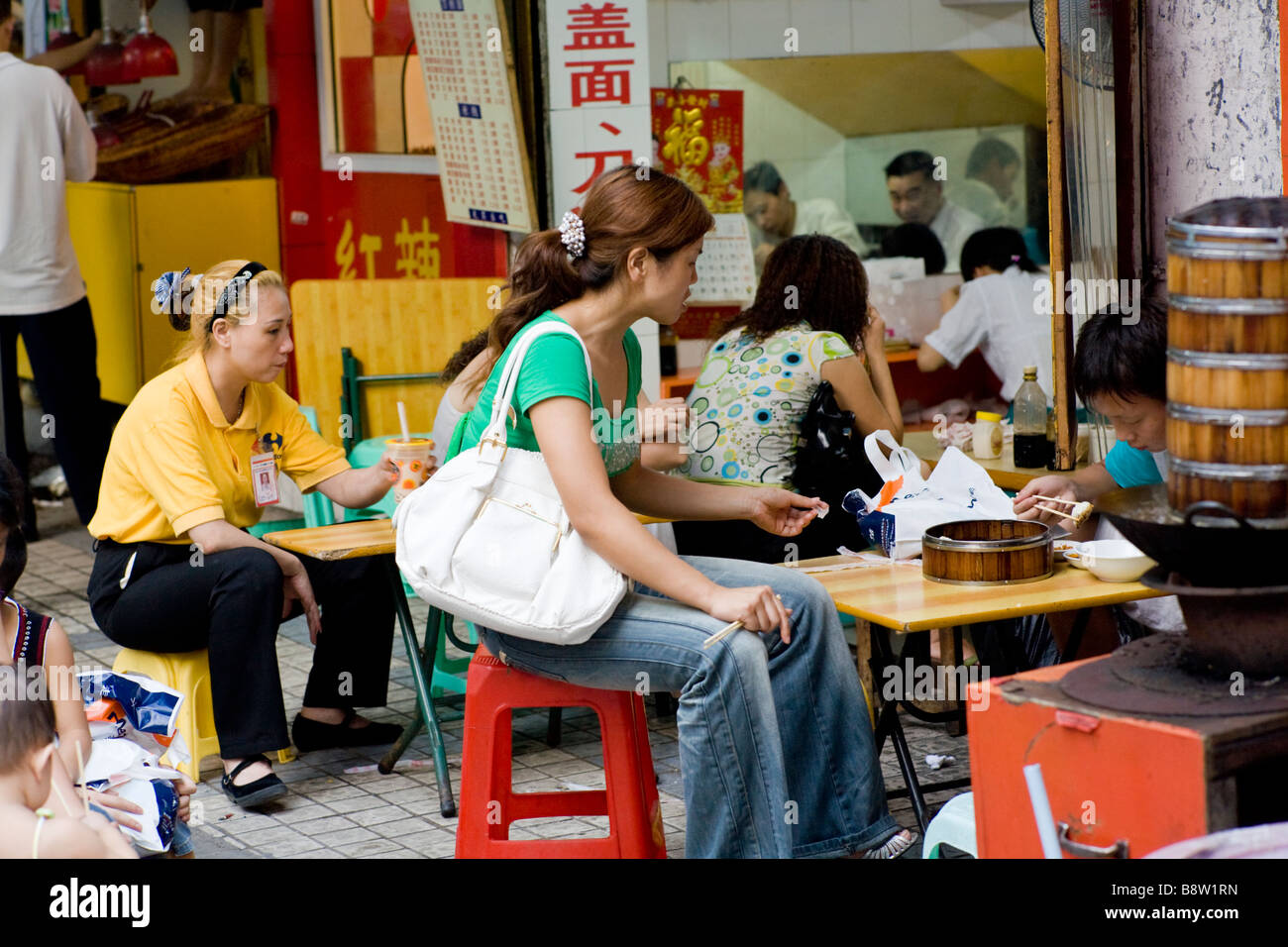 A dim sum snack restaurant on the sidewalk in downtown Chongqing, China ...