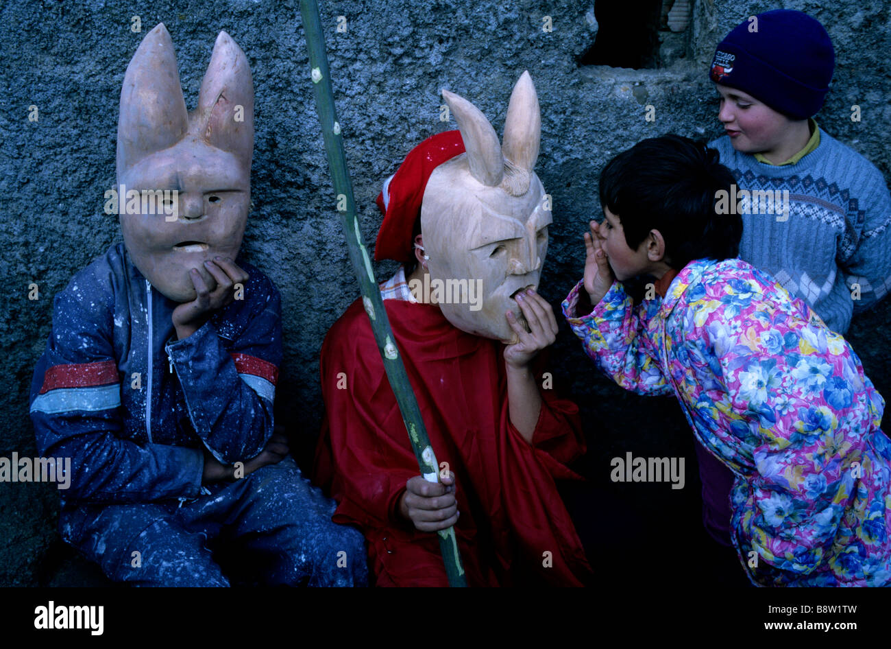Children tease two masked "devils" during the Caretos de Lazarim ...