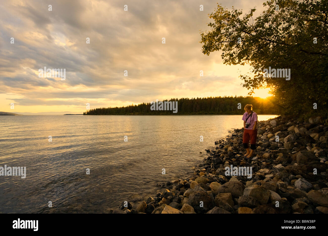 Young woman on lakeshore enjoying sunset Green Lake South Cariboo ...