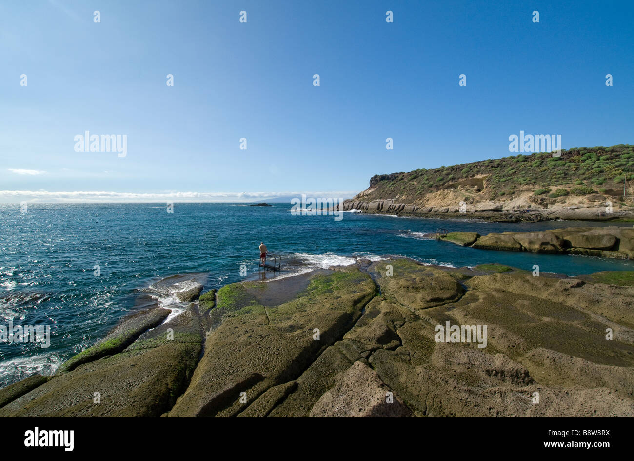Lone bather standing on diving board looking out to sea at La Caleta ...