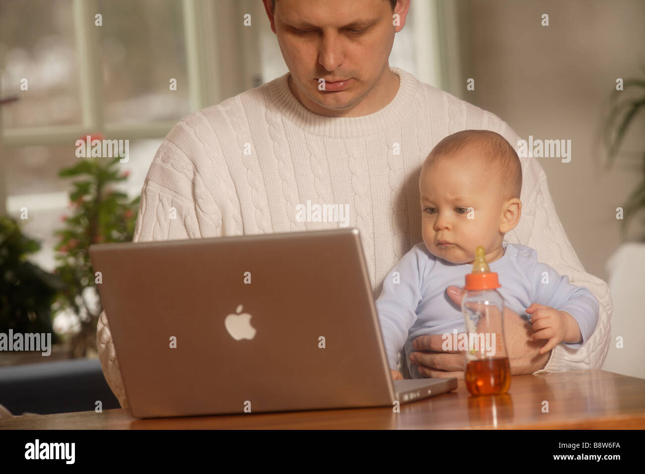 Son Watching Father Work on Laptop Stock Photo - Alamy