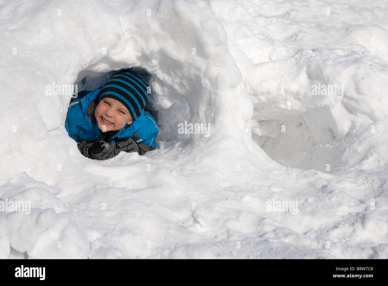 Young boy looking out from a snow cave Stock Photo - Alamy