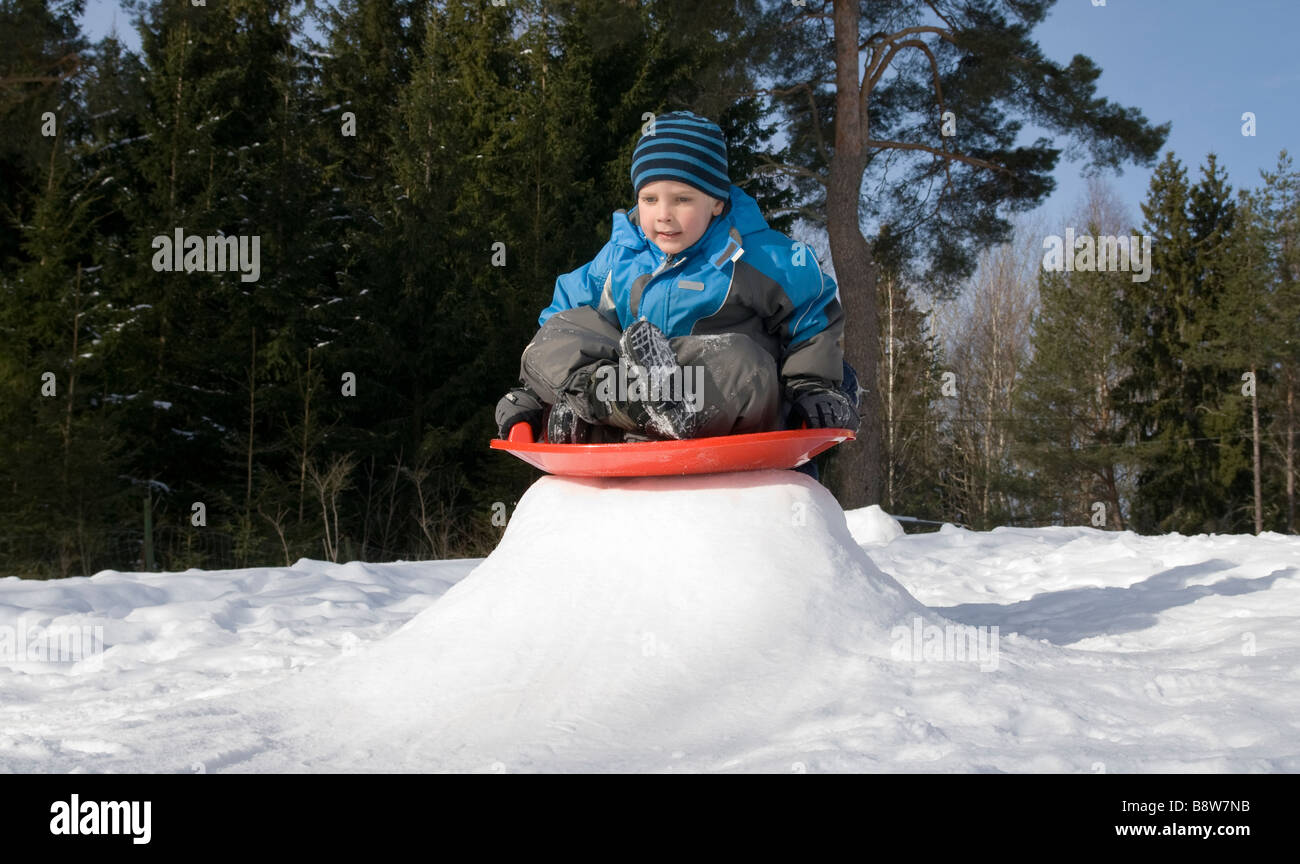 young boy playing with a sled from a hill Stock Photo - Alamy