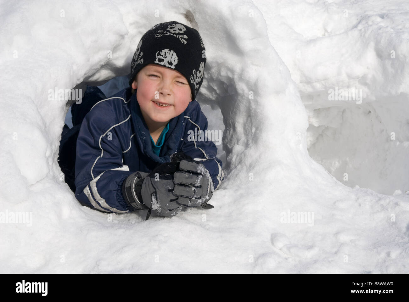 Young boy looking out from a snow cave Stock Photo - Alamy