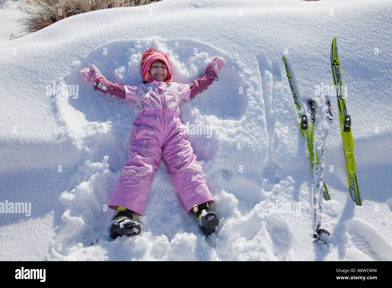 Girl making snow angel Stock Photo - Alamy