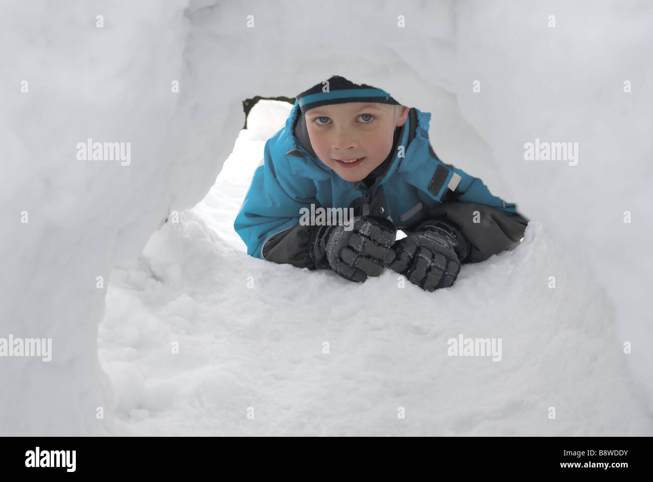 Young boy looking out from a snow cave Stock Photo - Alamy