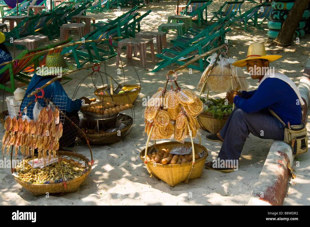Beach vendors with traditional yoke sell dried squid and pastry on Koh ...
