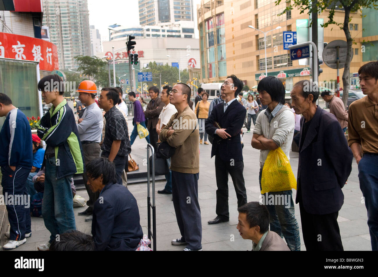 People gather to watch the latest soap opera on TV sets on display in a ...