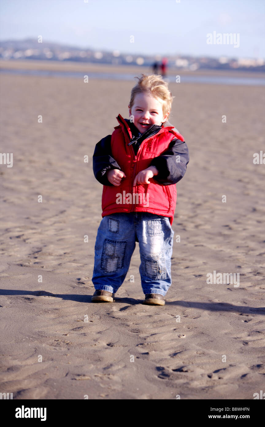 little boy in red jacket standing on a beach Stock Photo - Alamy