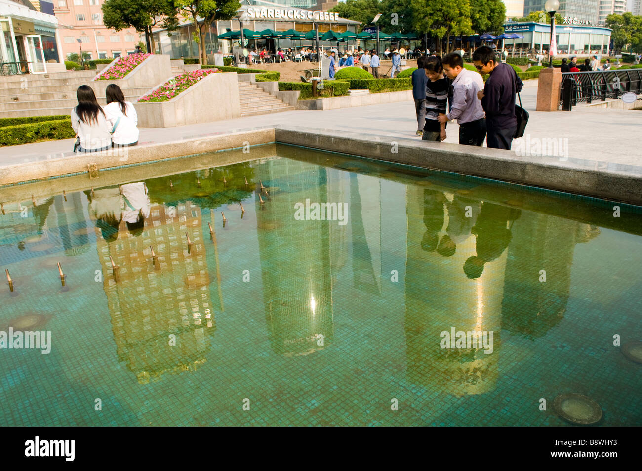 Skyscrapers seen in a reflection along the river promenade in Pudong ...