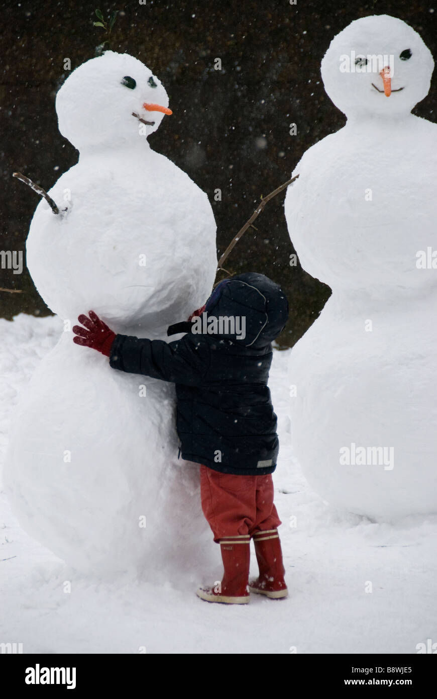 Young Child hugging a snowman during the February 2009 snow storm Stock ...